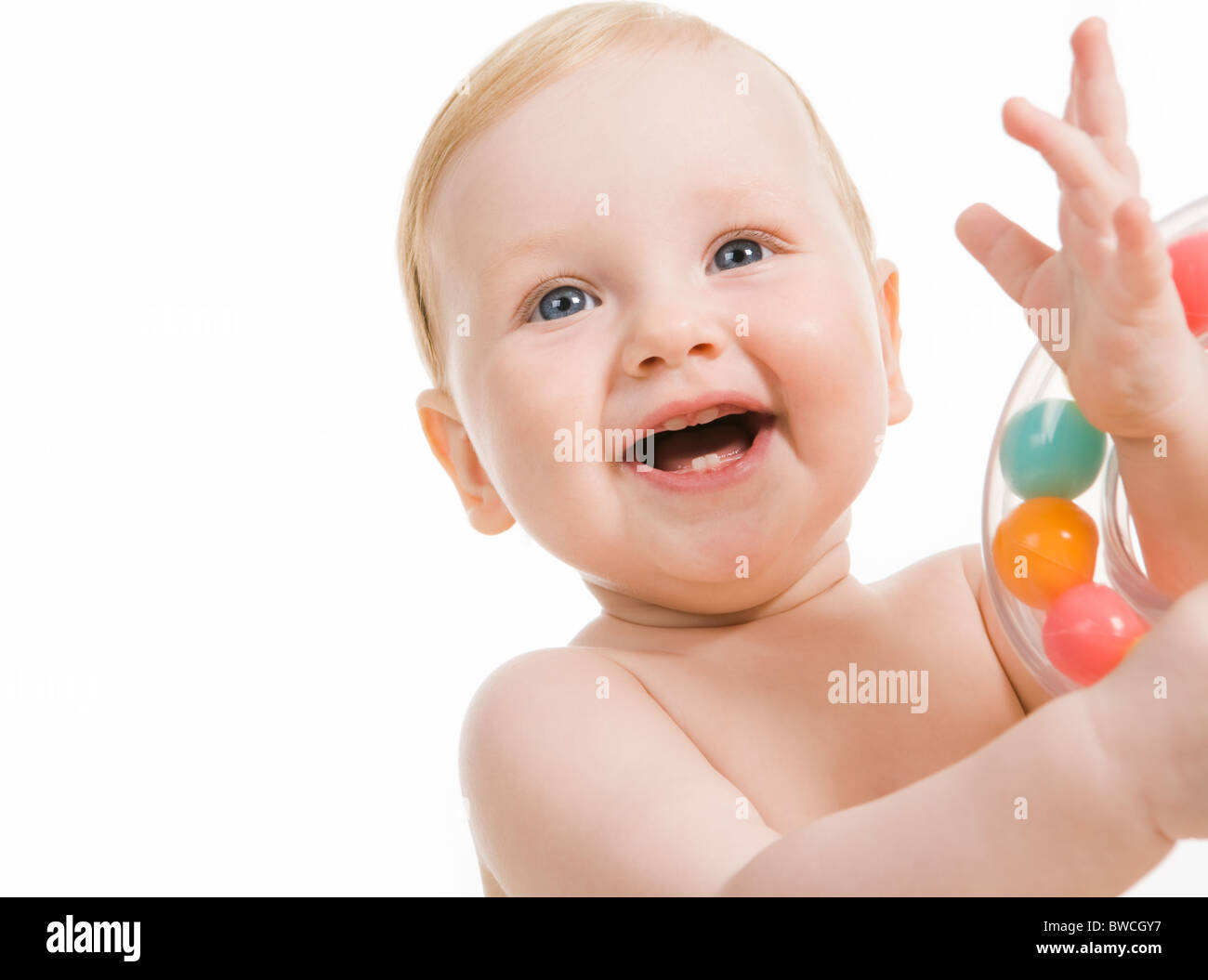 Photo of happy baby playing with toy and laughing over white background ...