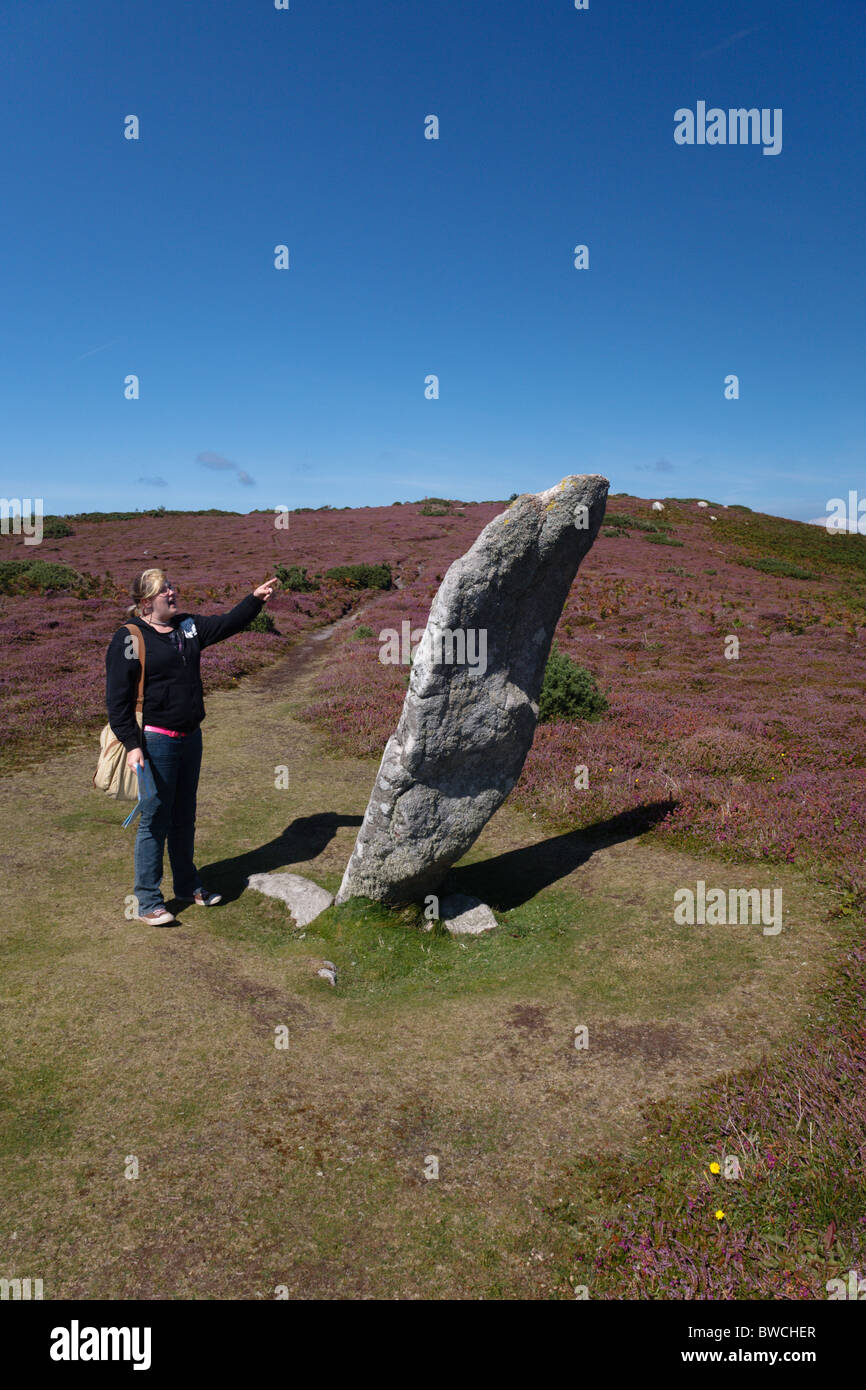 A teenage girl observes the Old Man of Gugh a Bronze age standing stone ...