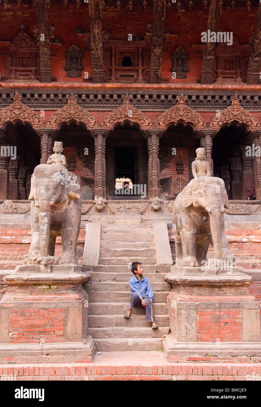 Boy looks up at a statue in Patan, Nepal Stock Photo - Alamy