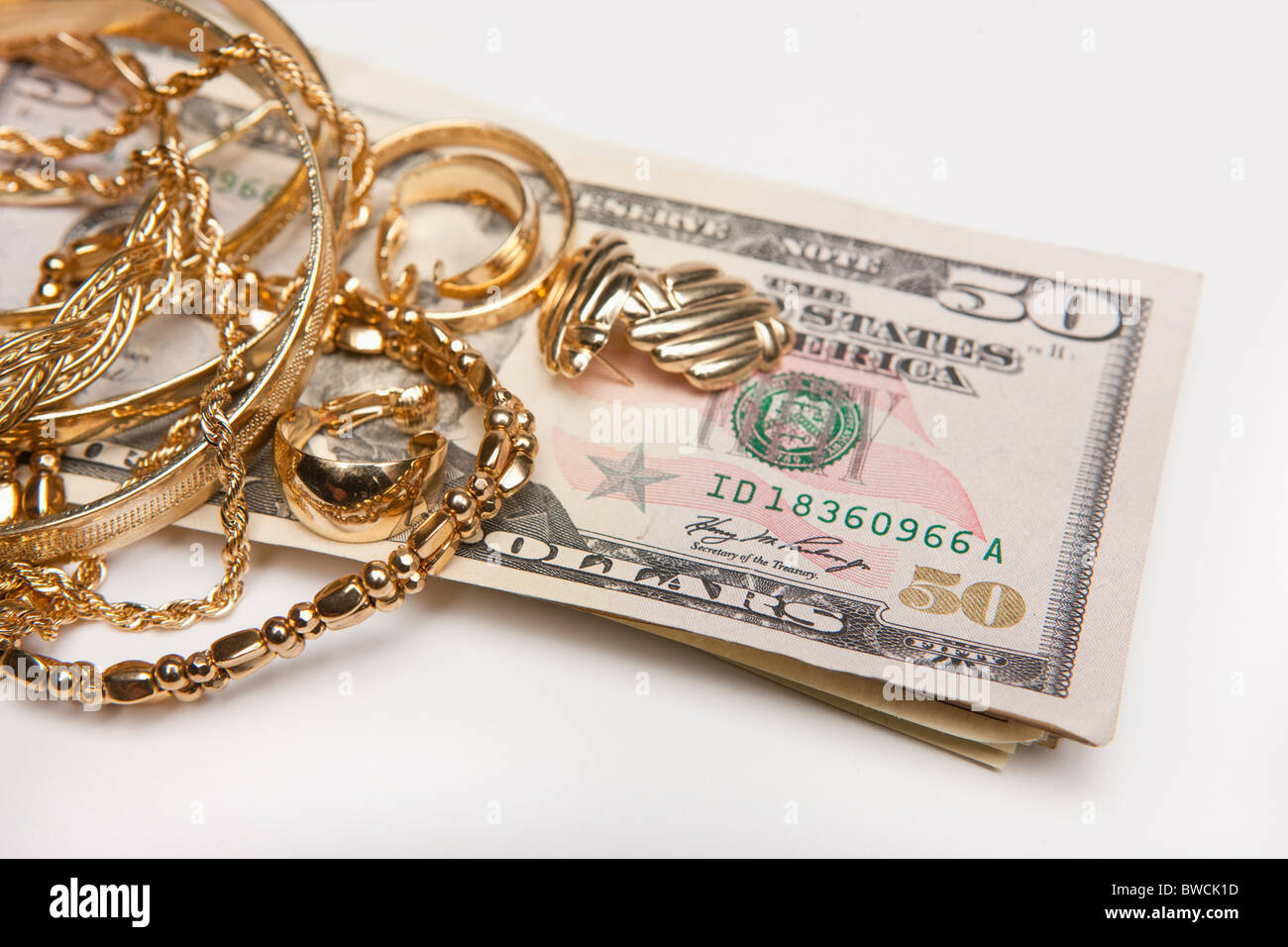 Golden jewelry and fifty dollar banknotes Stock Photo - Alamy
