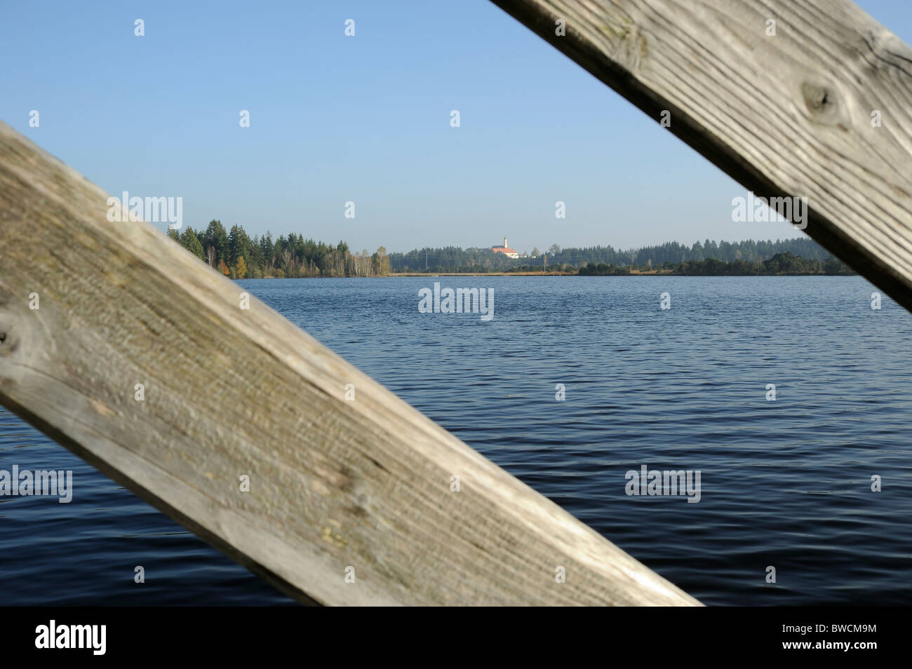 View of Kirchsee and monastery Sachsenkam through wooden parapet ...