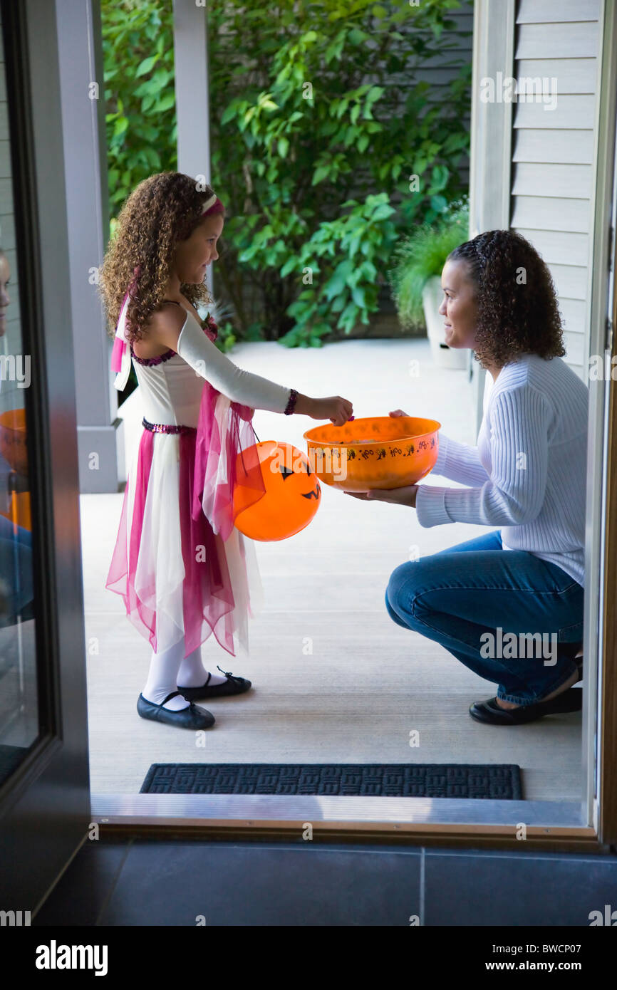 USA, Illinois, Metamora, Young woman giving candies to girl (6-7) in ...