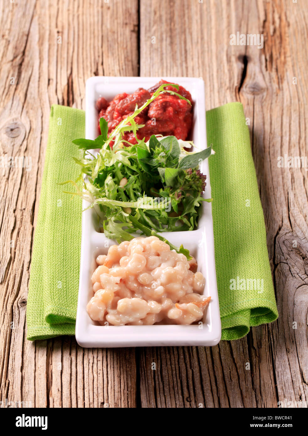 White beans, red bean salsa and salad greens Stock Photo - Alamy