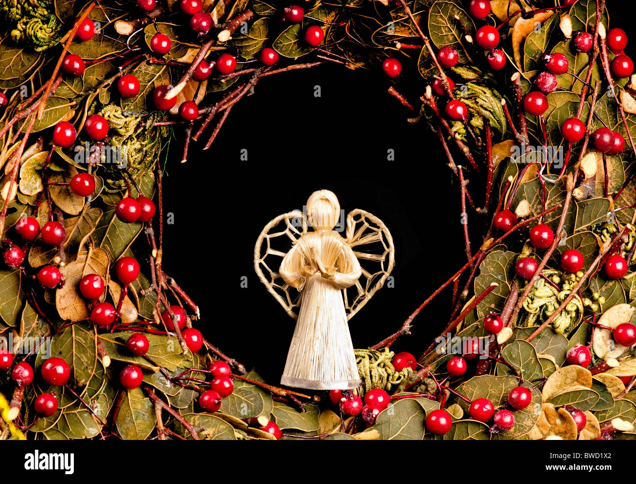 Decorative raffia Christmas angel inside a Christmas wreath with green ...