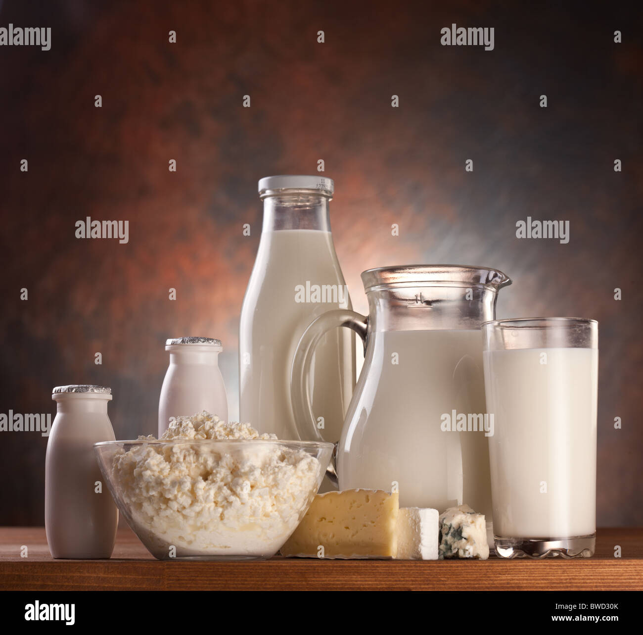 Different milk products: cheese, cream, milk, yohurt. On a brown ...