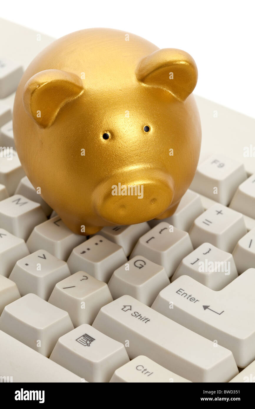 Golden Piggy Bank and computer keyboard Stock Photo - Alamy