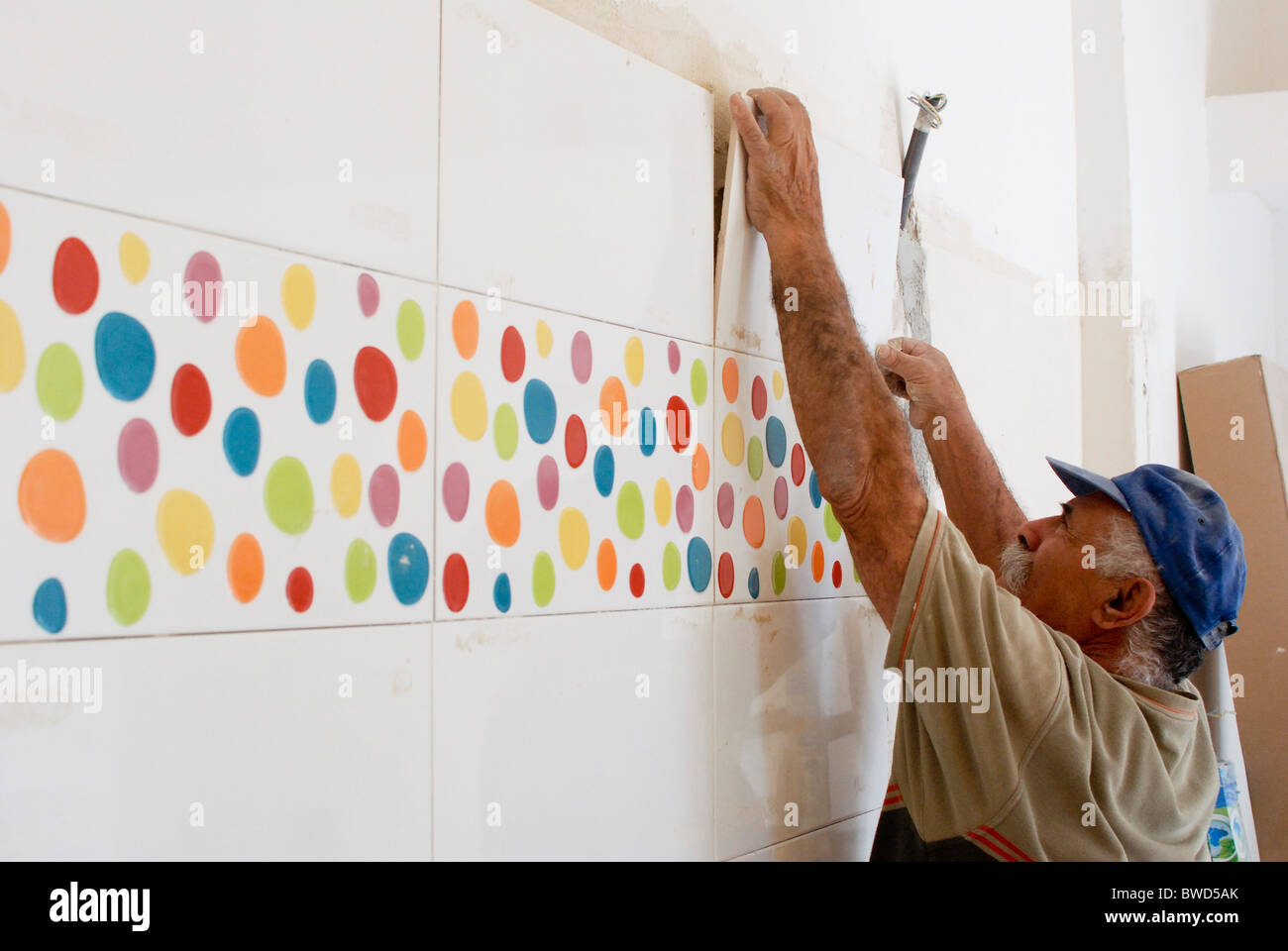 skilled Tiler at work laying tiles Stock Photo - Alamy