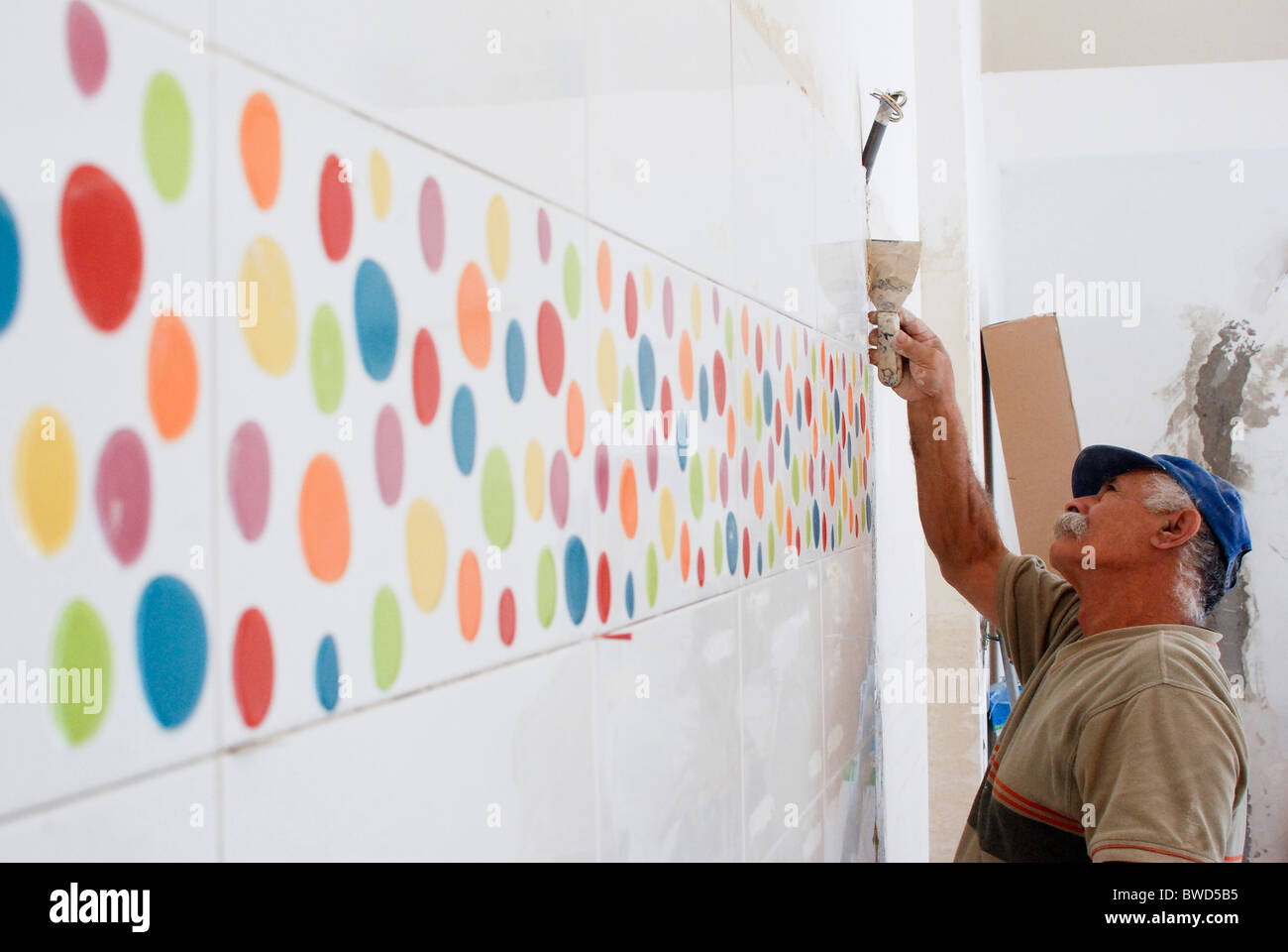 skilled Tiler at work laying tiles Stock Photo - Alamy