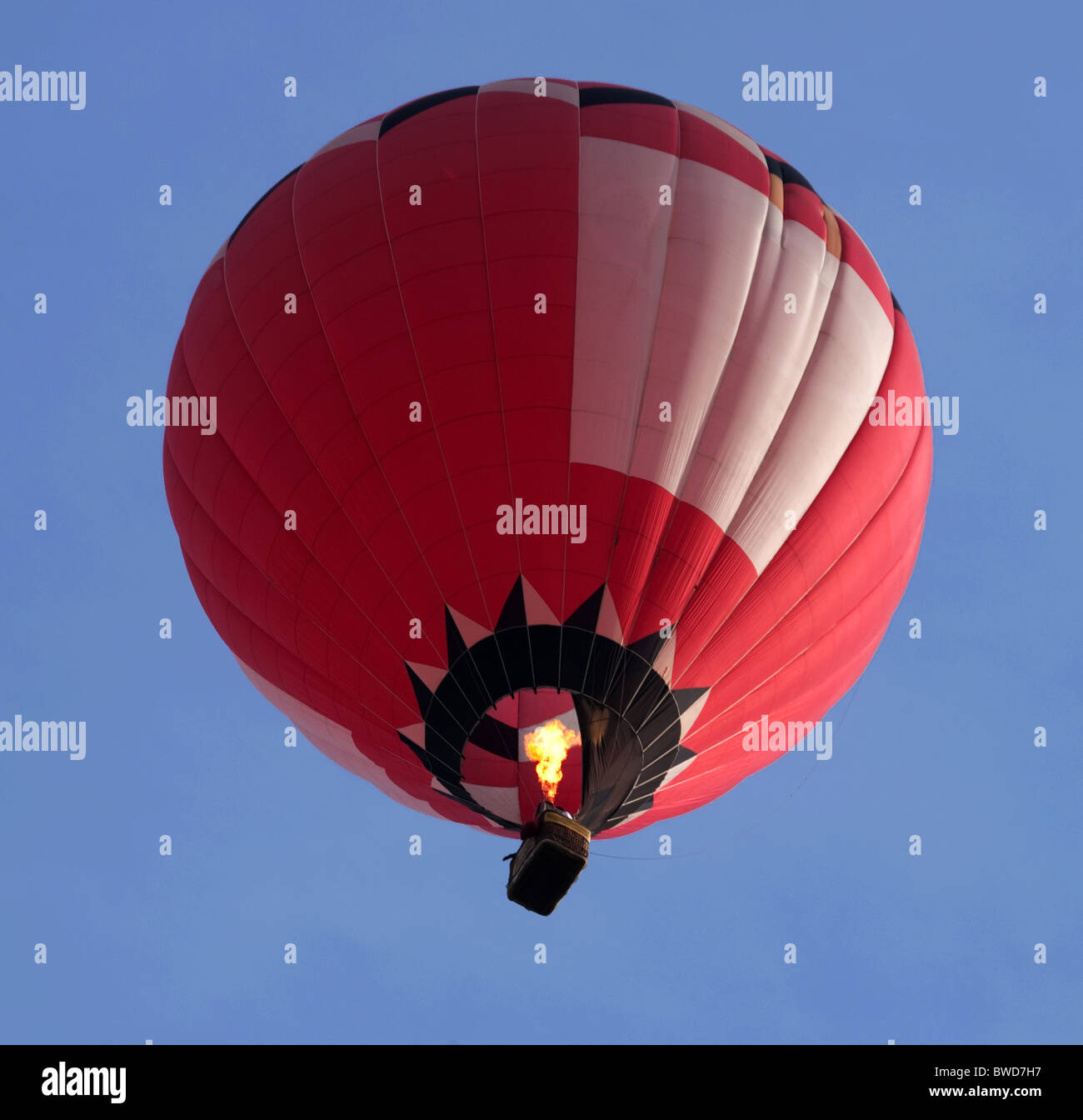 Red hit-air balloon in a blue sky filling the image, seen from below ...