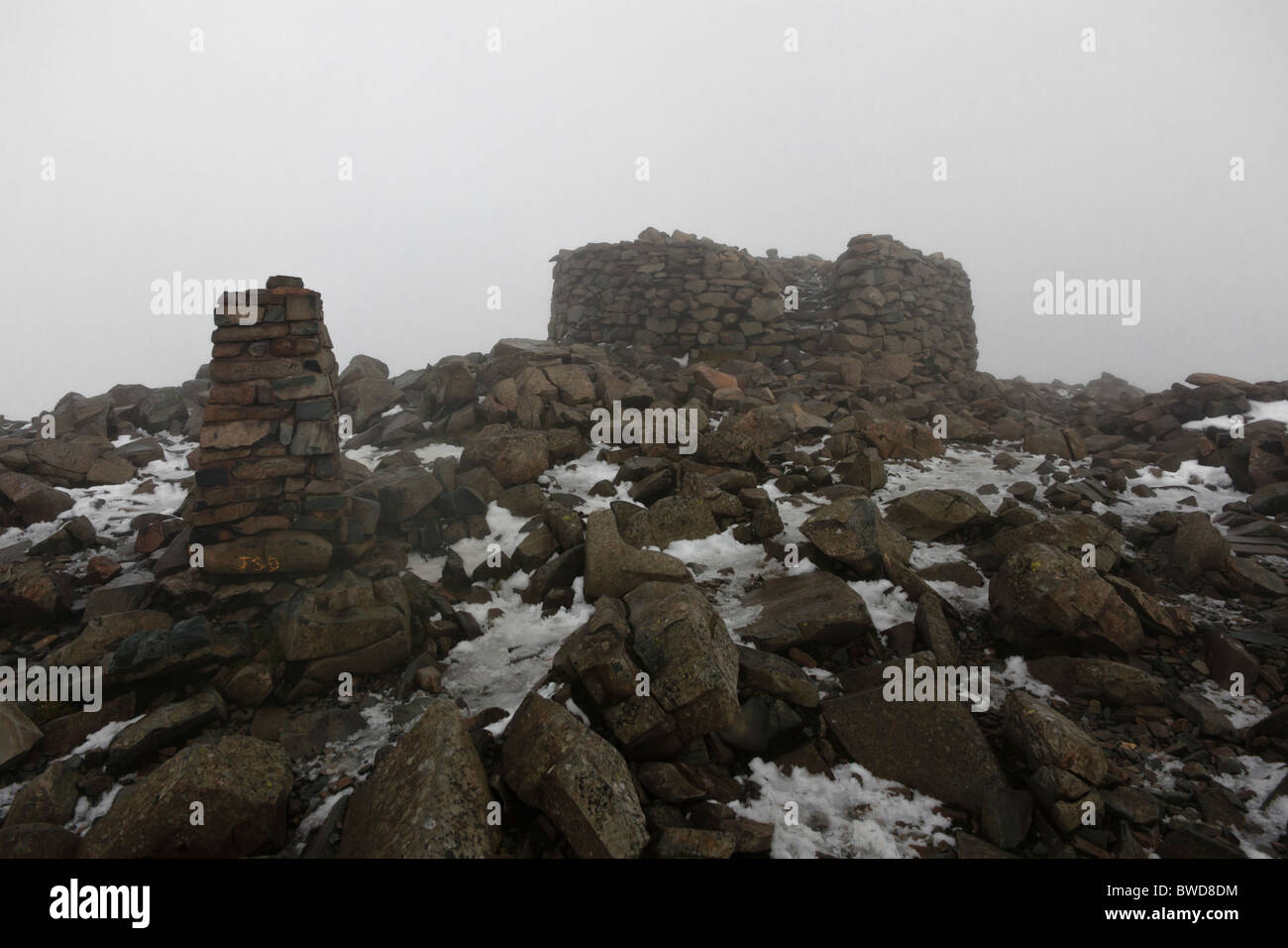 Scafell Pike summit cairn & trig pillar in cloud with patches of snow ...