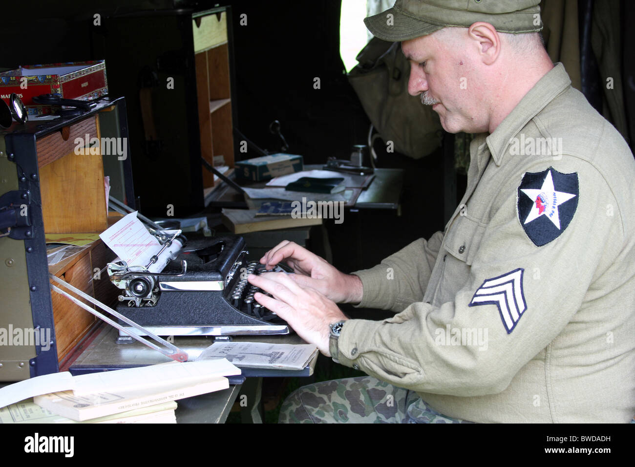A World War II clerk reenactor typing a form on a manual type writer ...