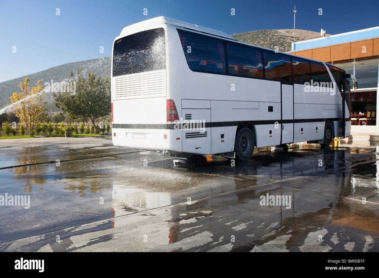 Tourist bus wash, water spraying from a garden hose Stock Photo - Alamy