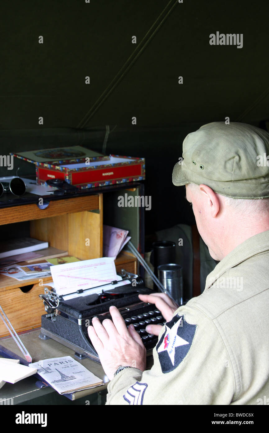 A World War II clerk reenactor typing a form on a manual type writer ...