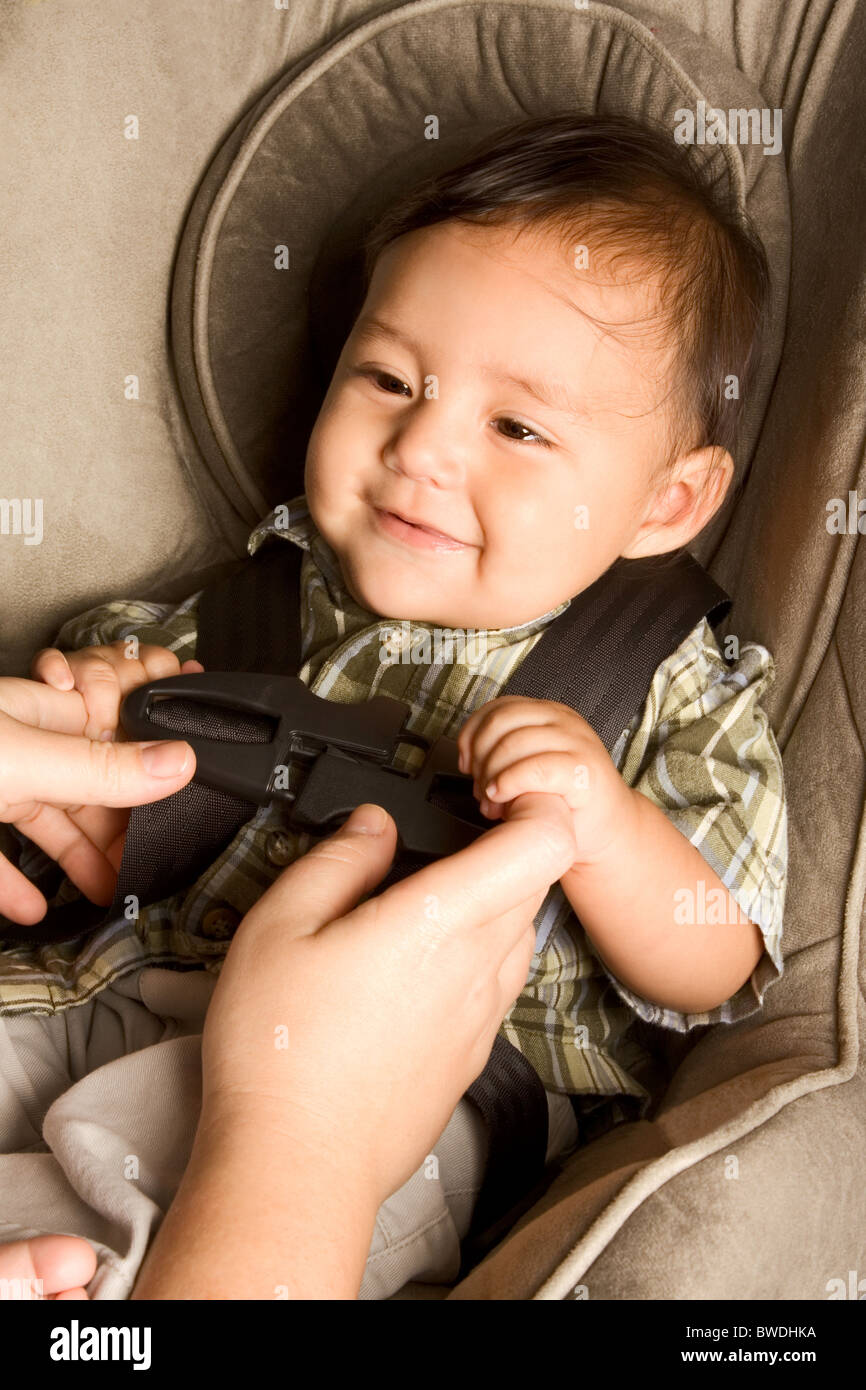 Smiling biracial Asian Filipino kid sitting in car seat while parent ...