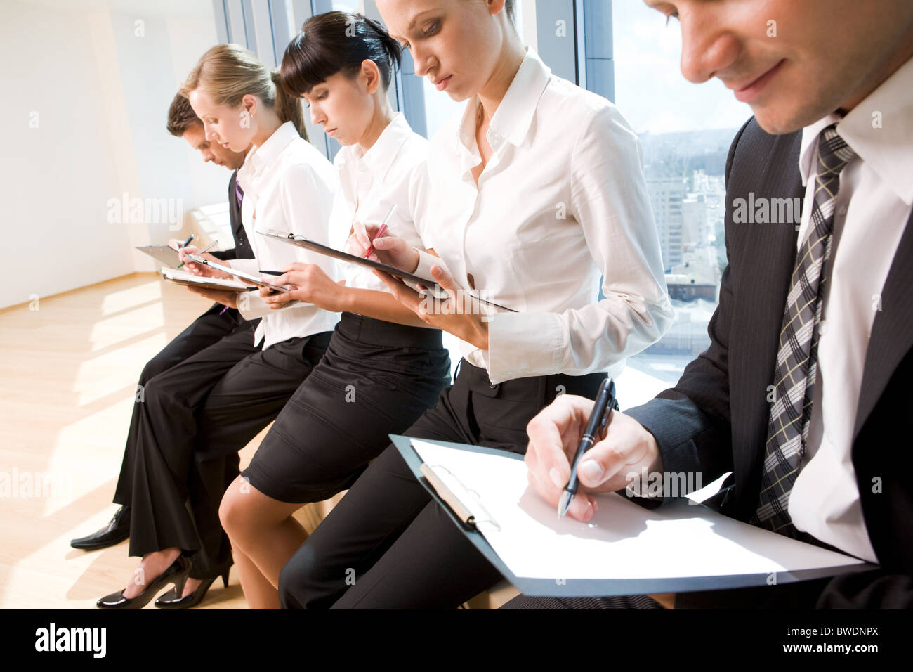 Image of row of business people writing on papers at seminar Stock ...