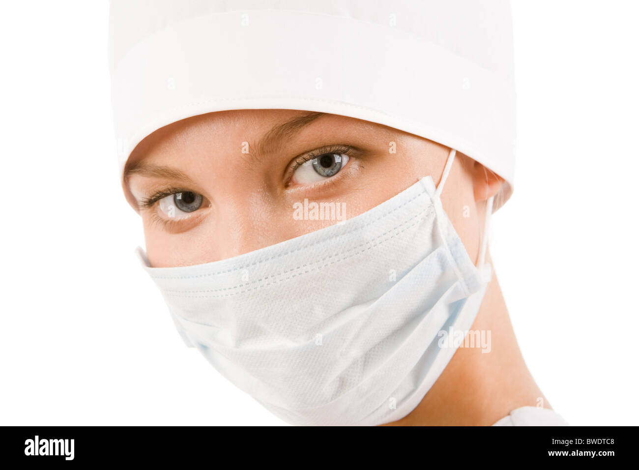 Face of nurse in sterile mask looking at camera over white background ...