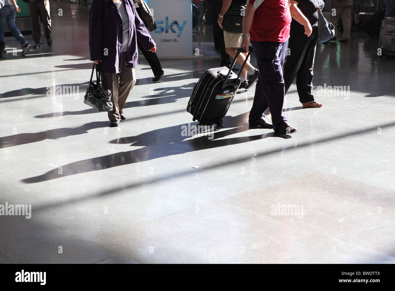 people pulling trolley cases in sunlit station concourse Stock Photo ...