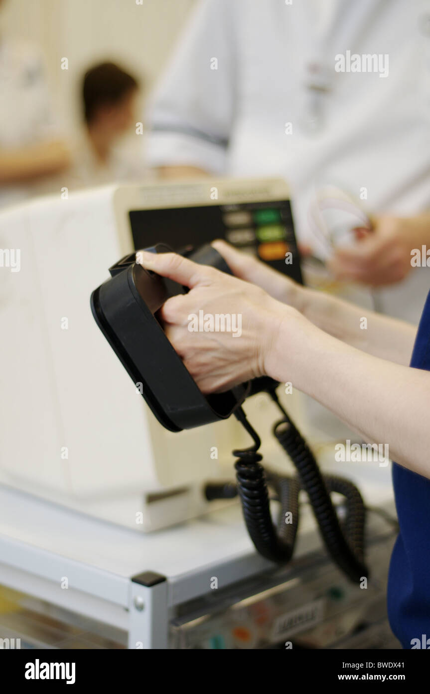 Medical staff using a defibrillator in a training ward in a hospital ...