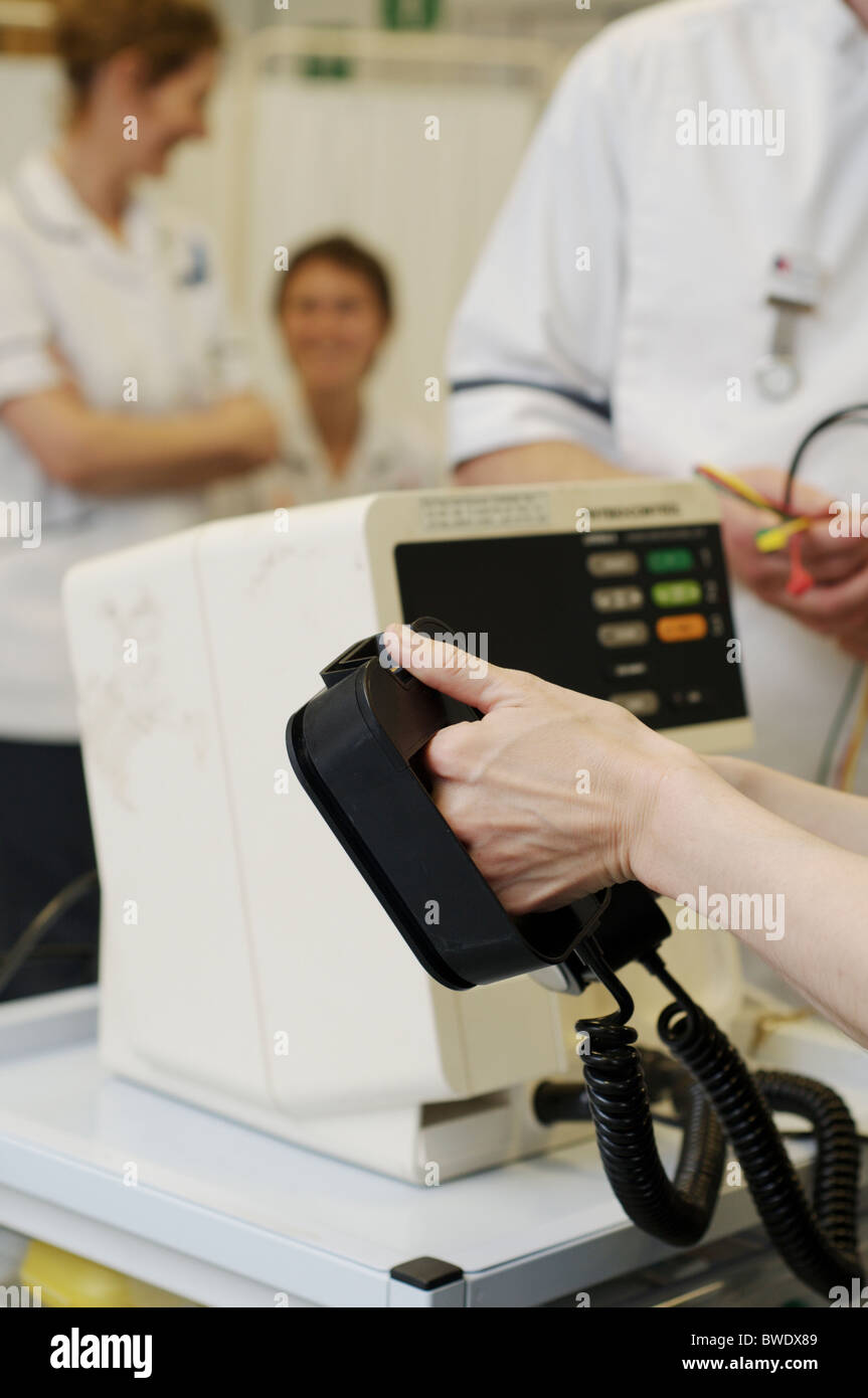 Medical staff using a defibrillator in a training ward in a hospital ...
