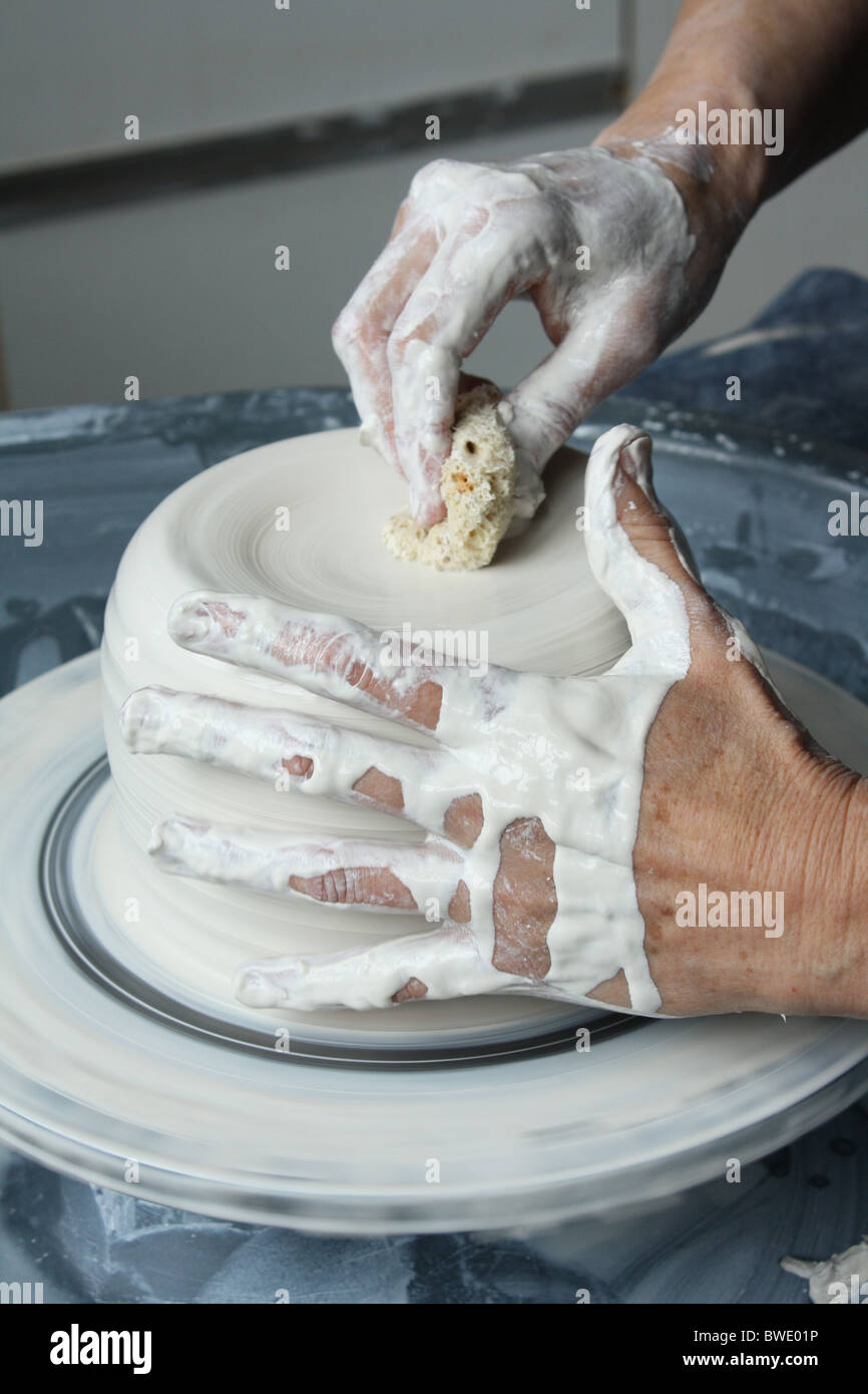 Potter throwing a porcelain pot and using a sponge Stock Photo - Alamy
