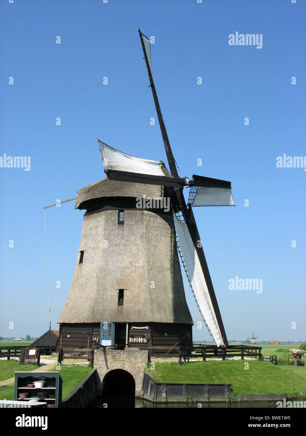 Thatched water pumping windmill Stock Photo - Alamy