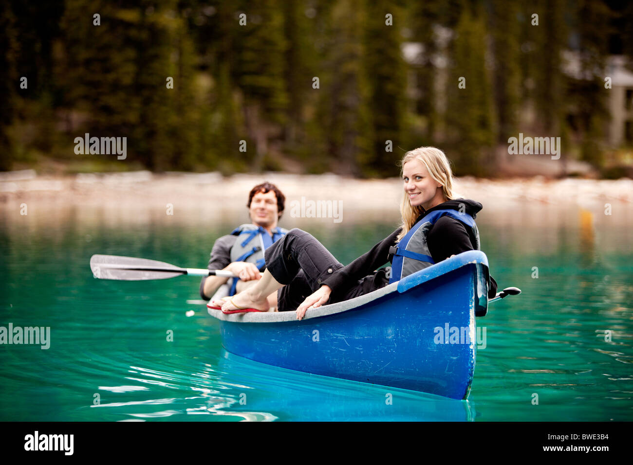 A happy couple relaxing in a canoe on a glacial lake Stock Photo - Alamy