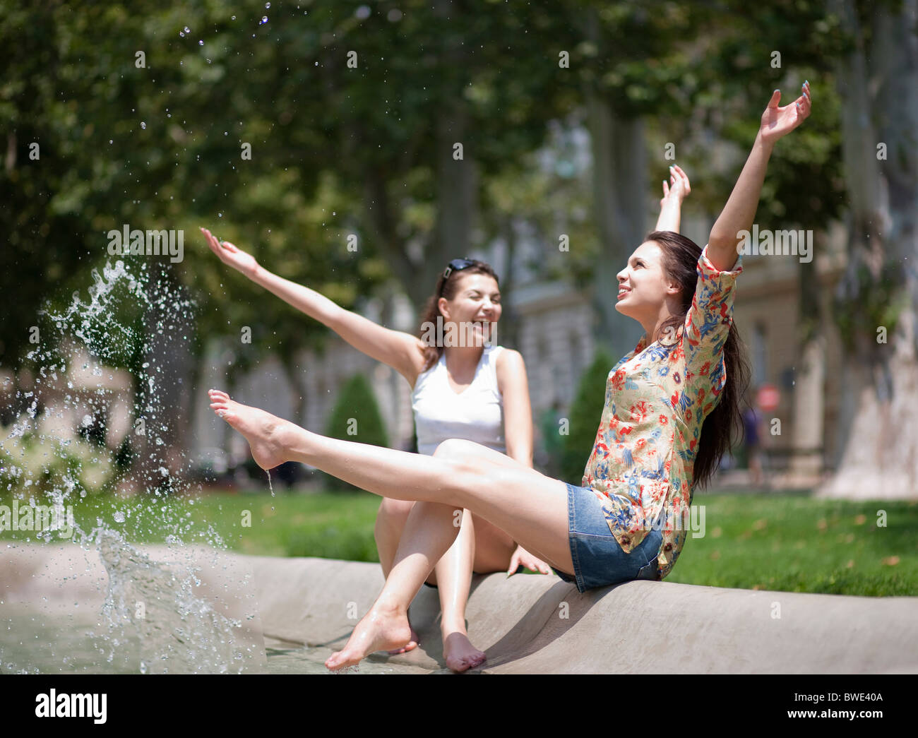 Young women splashing in a fountain Stock Photo - Alamy