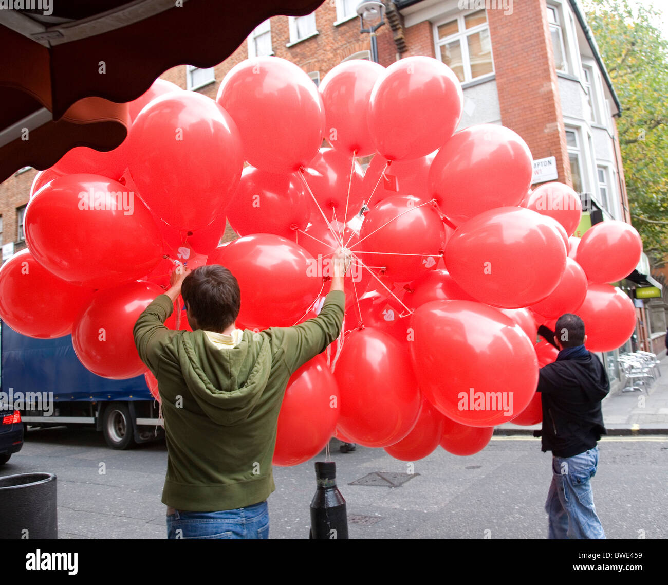 Men Carrying red Balloons Stock Photo - Alamy