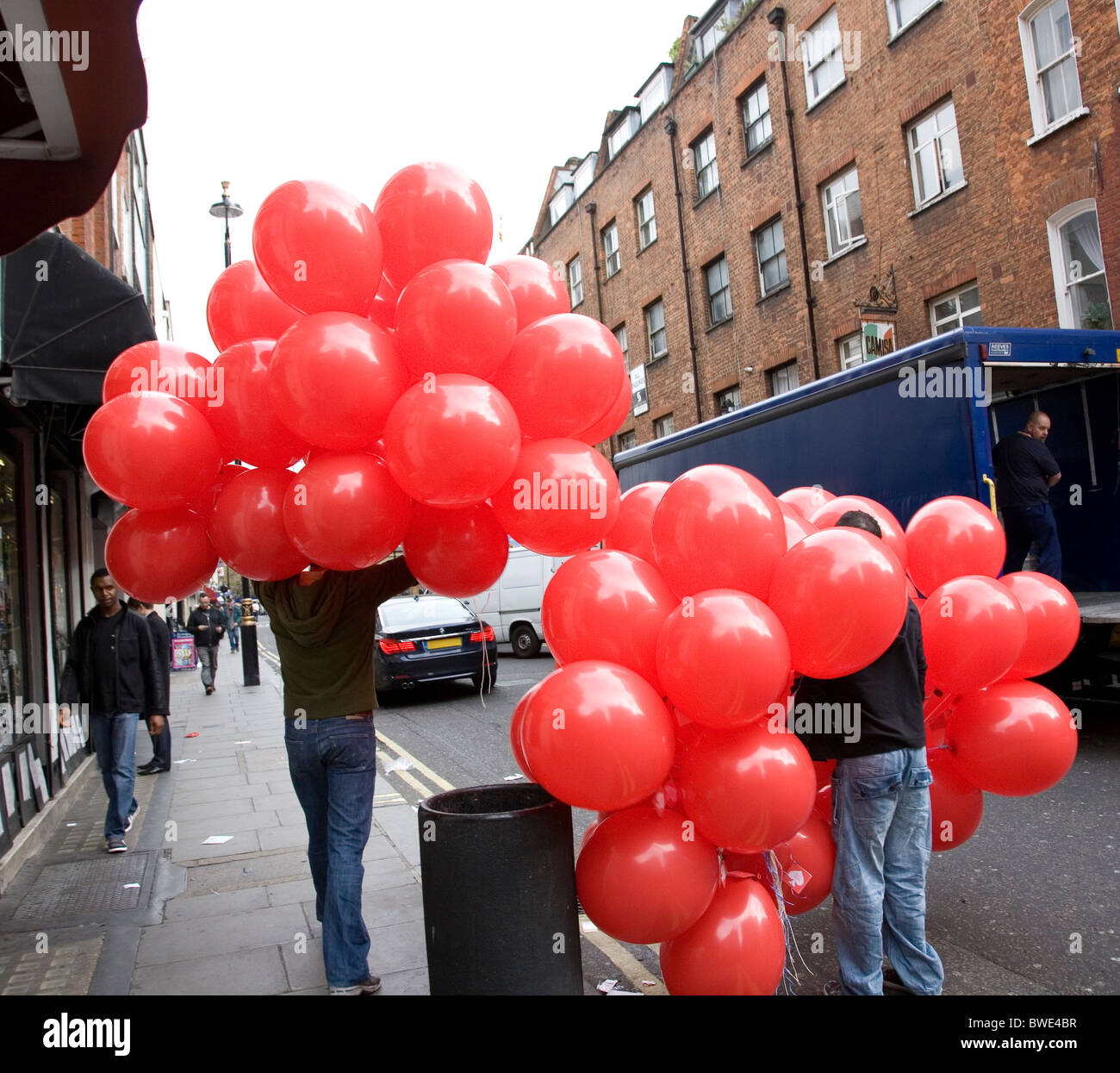 Men Carrying red Balloons Stock Photo - Alamy