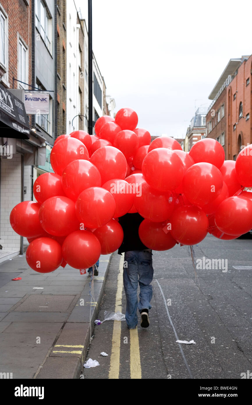 Man Carrying red Balloons Stock Photo - Alamy