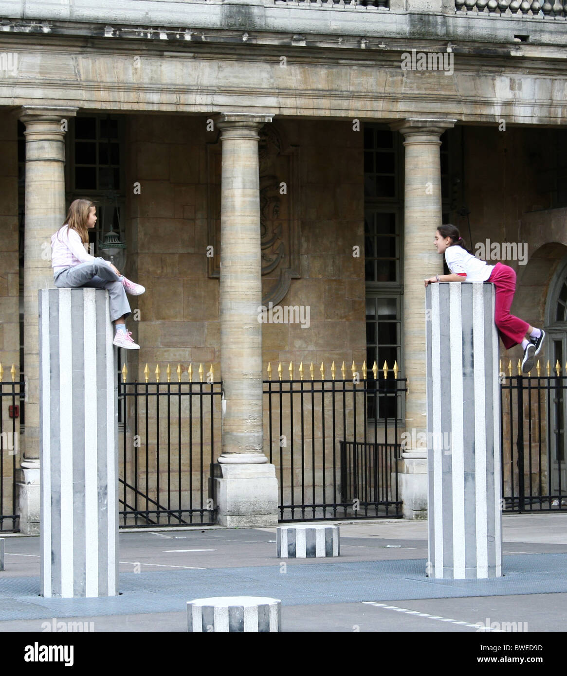 Two girls playing on columns from the artistic installation of Buren in ...