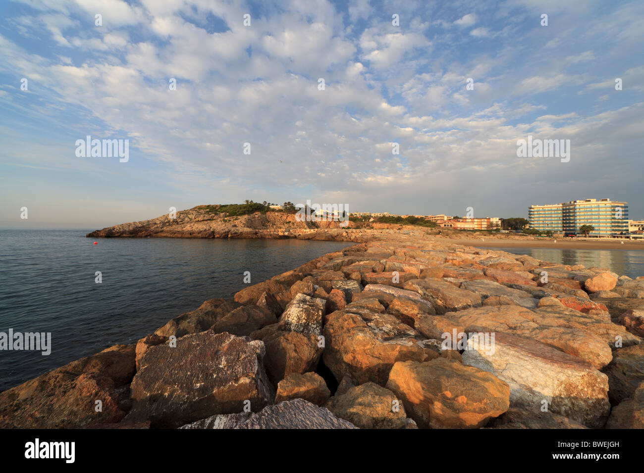 A stone pier in the resort town of La Pineda in Spain at the dawn Stock ...
