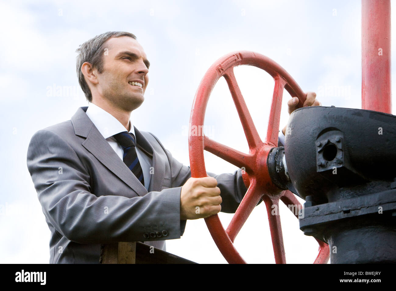 Portrait of strong leader holding rudder and looking forwards with ...