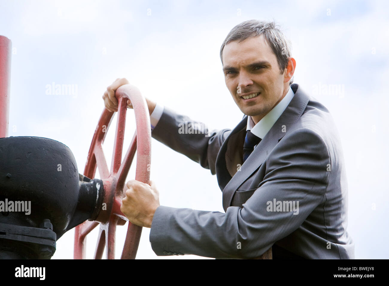 Portrait of confident captain holding rudder and looking at camera with ...