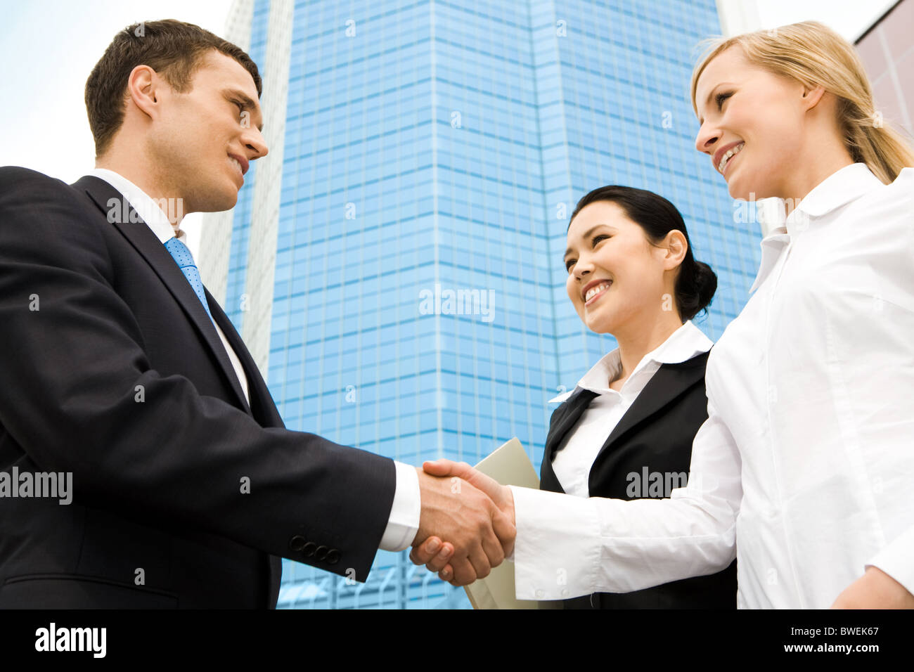 Image of successful partners handshaking at background of modern ...