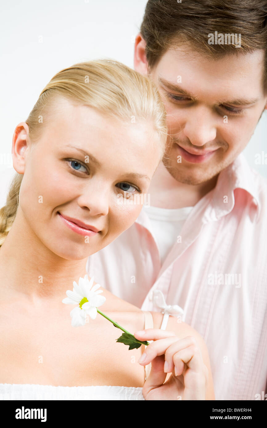 Lovely female holding white flower with amorous guy at background Stock ...