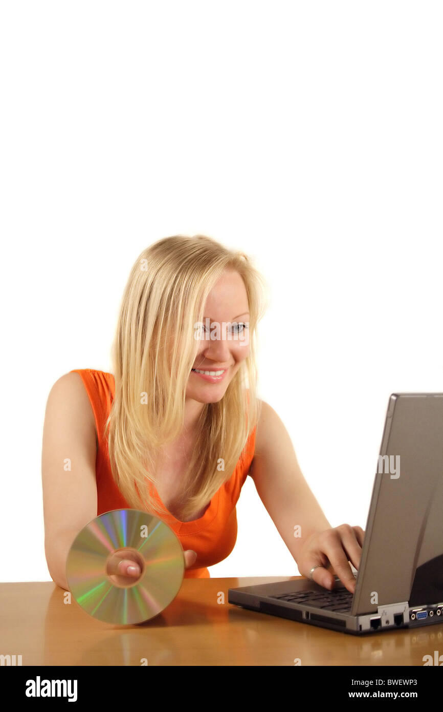 An attractive young woman installing software on her notebook computer ...
