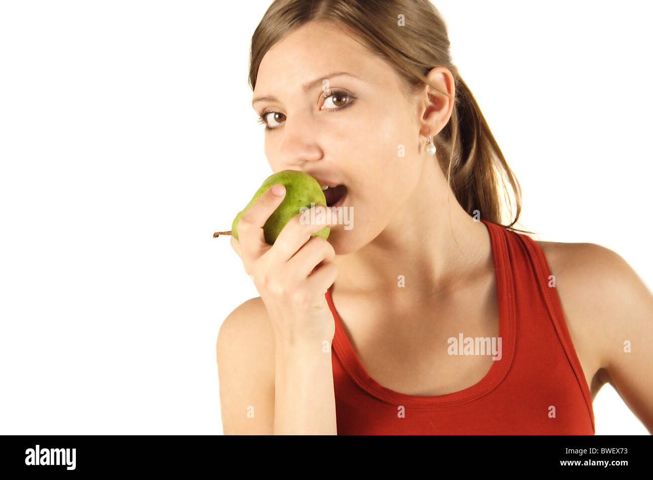 A young handsome woman eating a pear. All isolated on white background ...