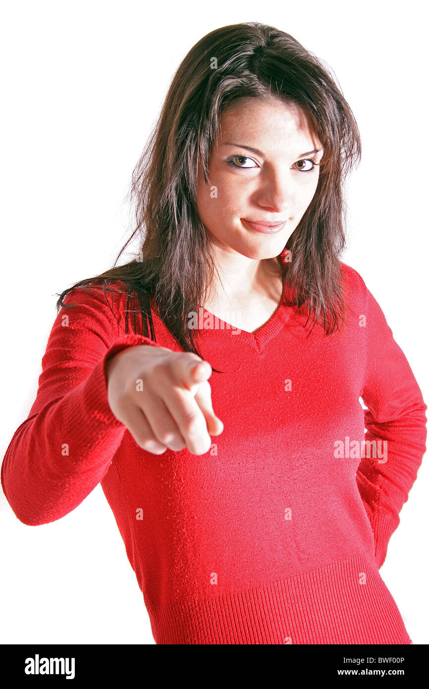 A handsome young woman points with her finger at someone or something ...