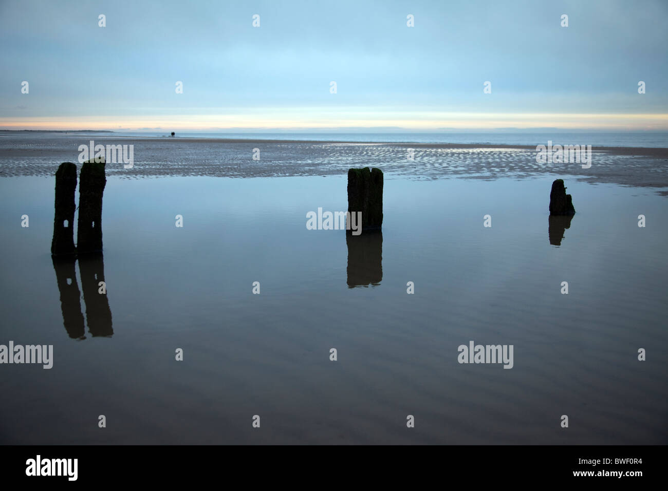Distant couple walk the beach Stock Photo - Alamy