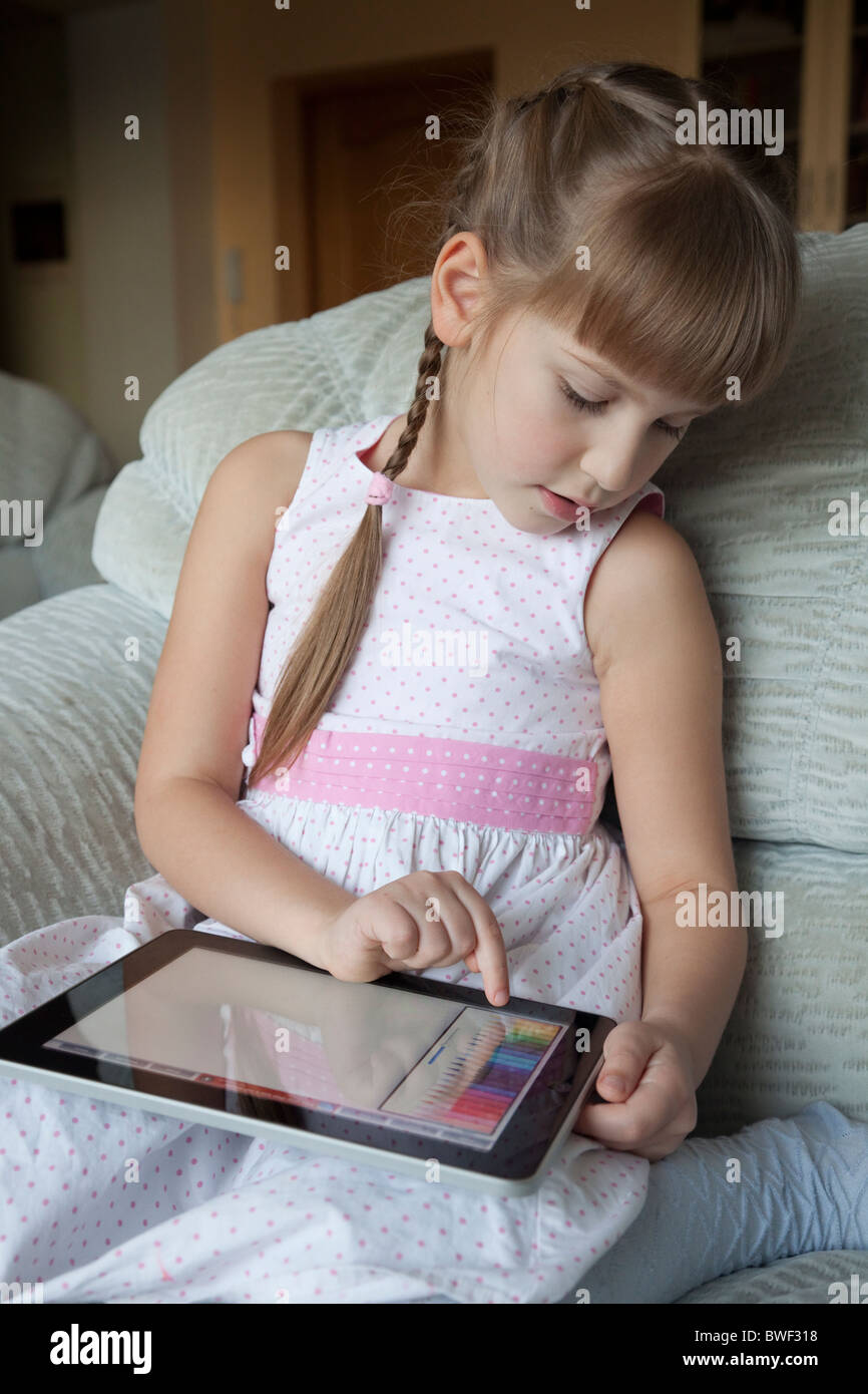 Little girl is using Apple iPad to draw and entertain herself at home ...