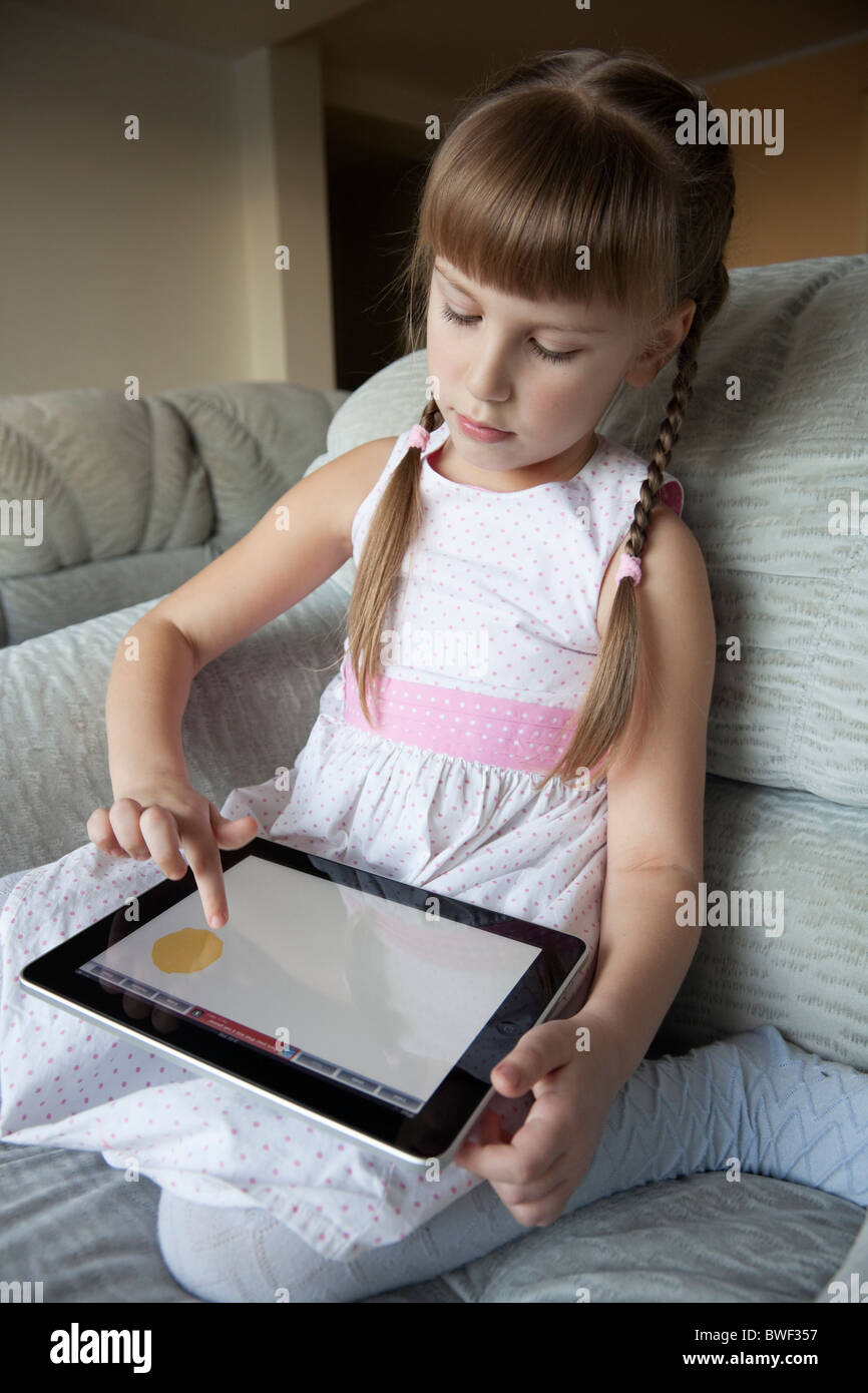Little girl is using Apple iPad to draw and entertain herself at home ...