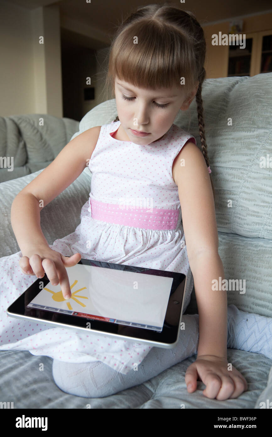 Little girl is using Apple iPad to draw and entertain herself at home ...