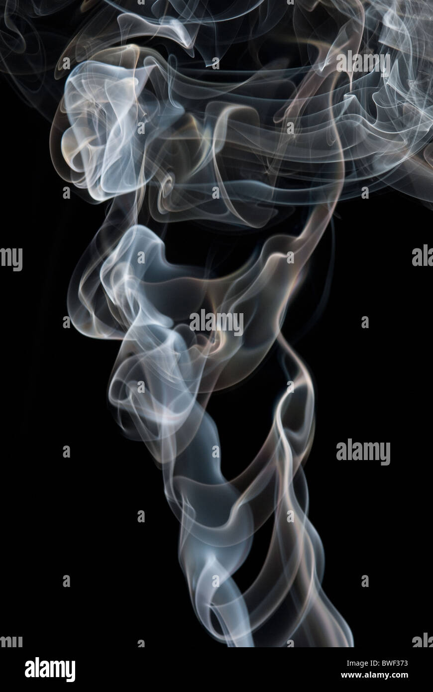 wavy smoke trail against black background creating patterns calmness ...