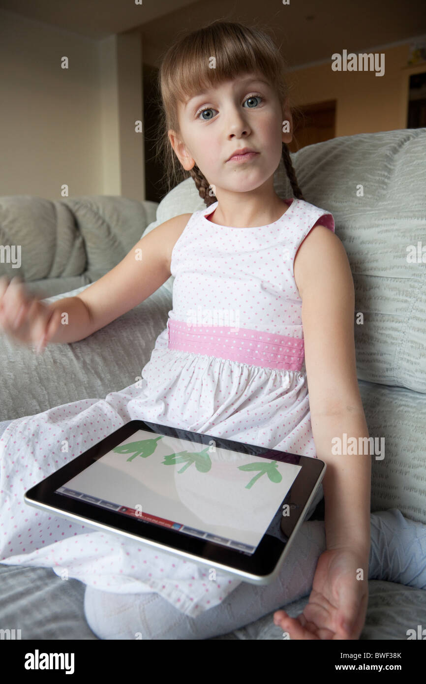 Little girl is using Apple iPad to draw and entertain herself at home ...