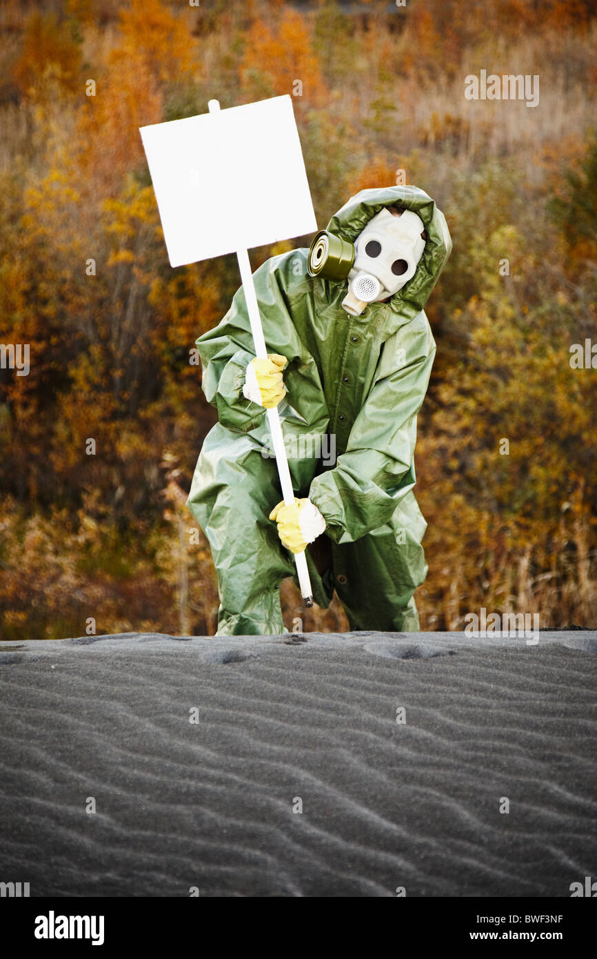 Scientist in protective suit and gas mask carry poster Stock Photo - Alamy