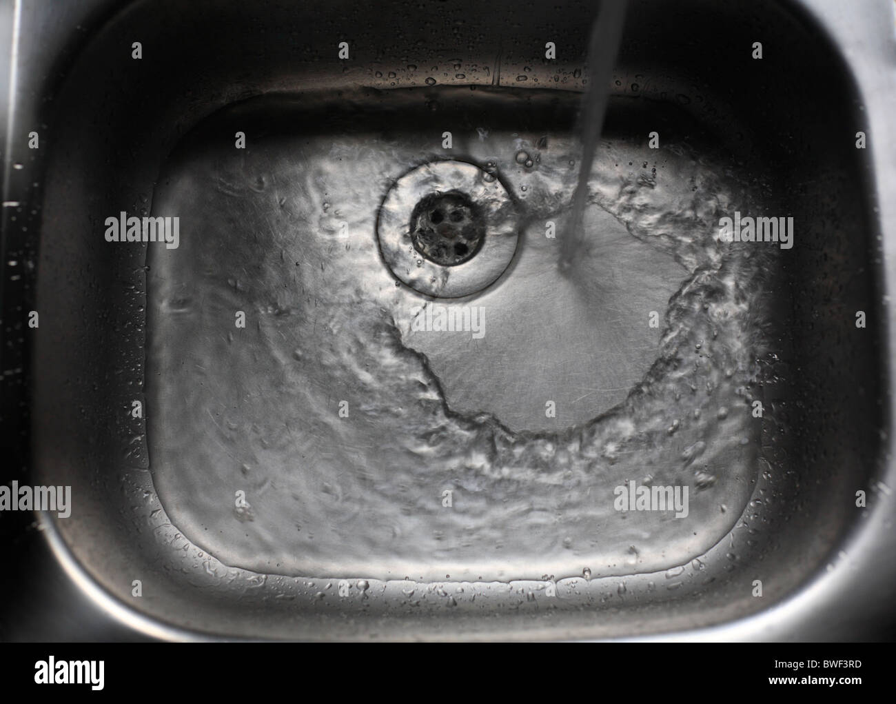 Running cold water in a kitchen sink Stock Photo - Alamy
