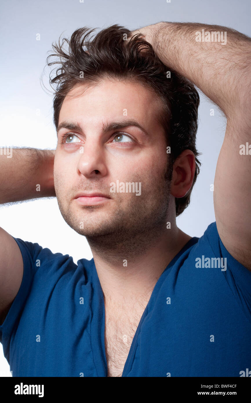 portrait of a man in blue top looking up - isolated on gray Stock Photo ...