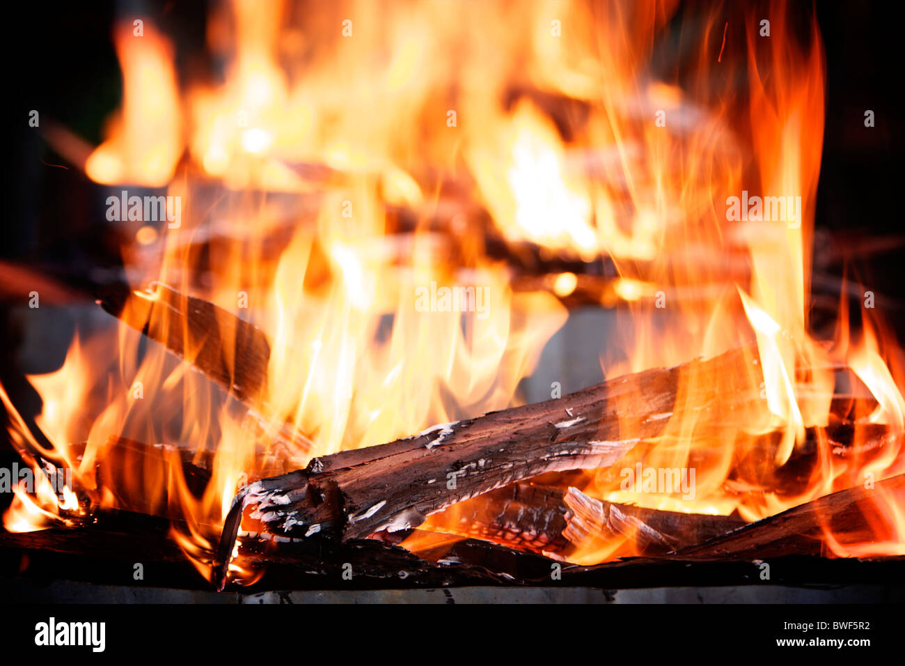 Flames shoot upwards from a raging outdoor log fire Stock Photo - Alamy