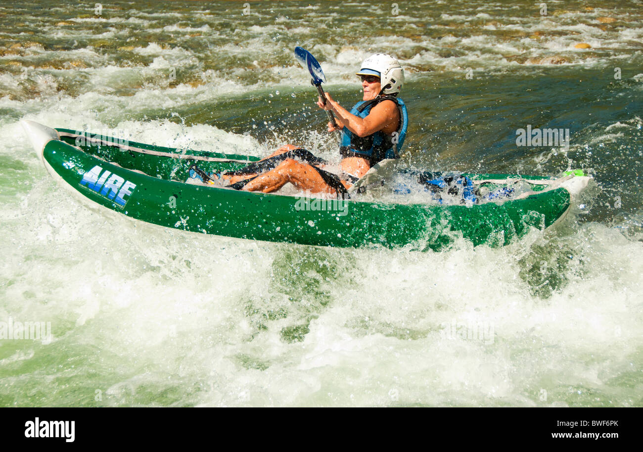 USA, Idaho, Mature Woman paddling kayak through churning whitewater ...